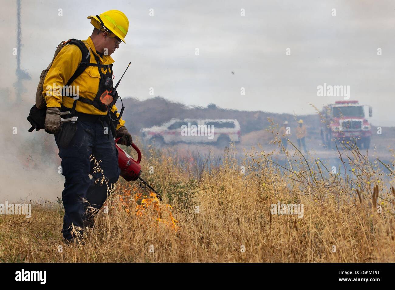 A firefighter with the Camp Pendleton Fire Department ignites brush ...