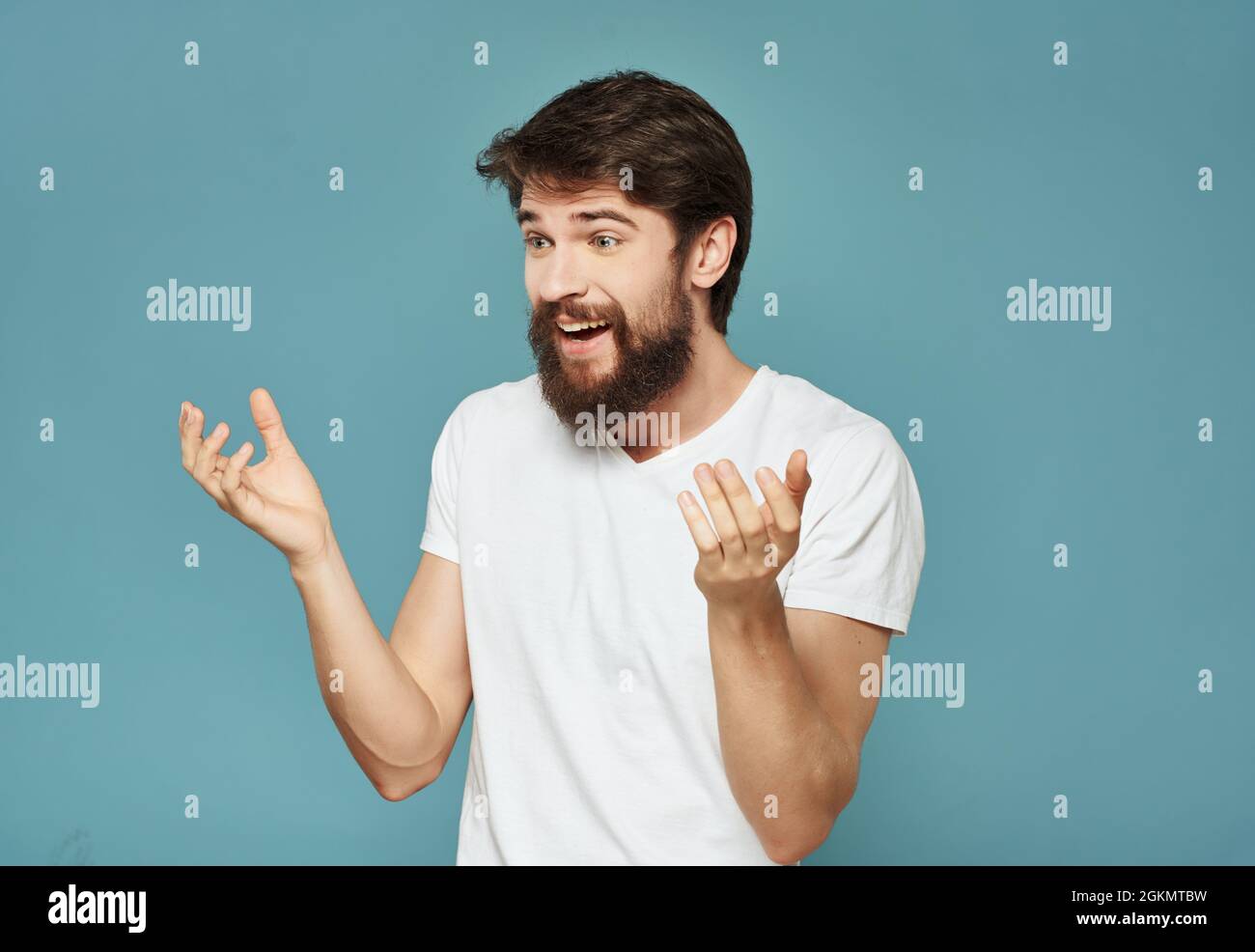 Man in a white t-shirt hand gestures anger blue background Stock Photo ...