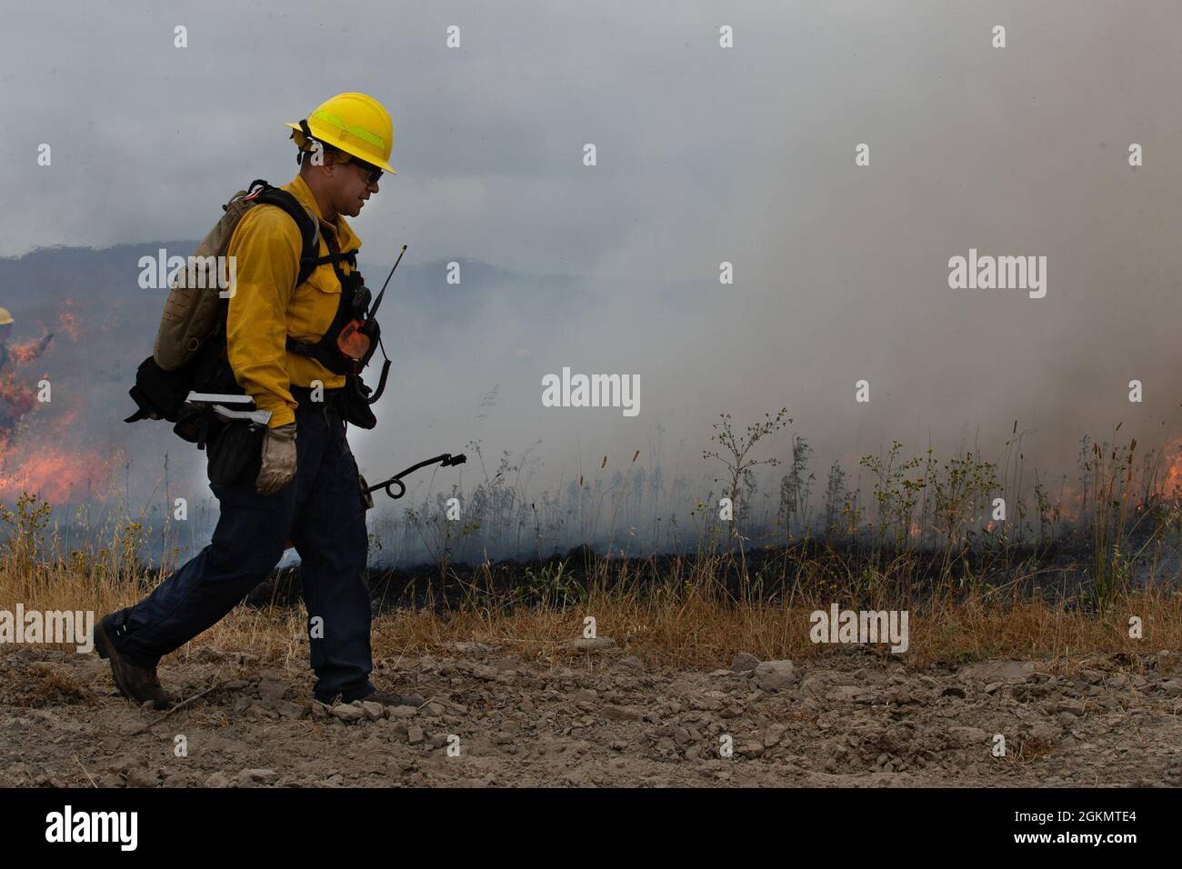 A firefighter with the Camp Pendleton Fire Department ignites brush ...