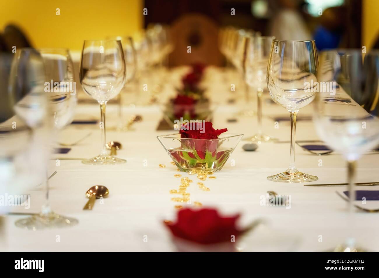 Set up of table with wine glasses, roses and tableware Stock Photo - Alamy