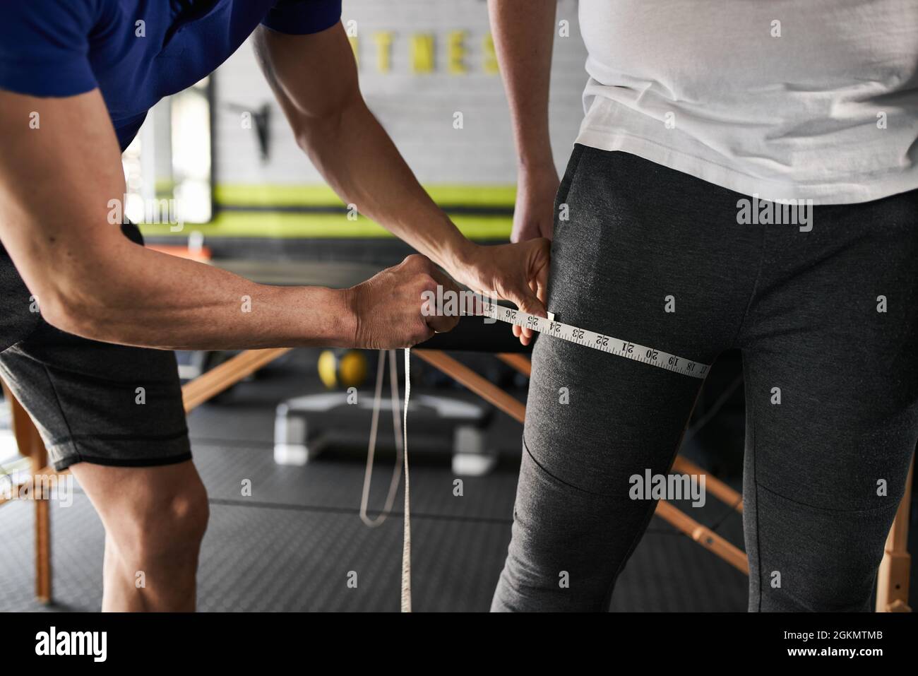 Close up of two unrecognizable people. Personal trainer measuring ...