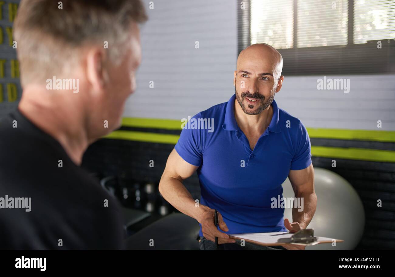 Male physio therapist and wellness personal trainer having a ...