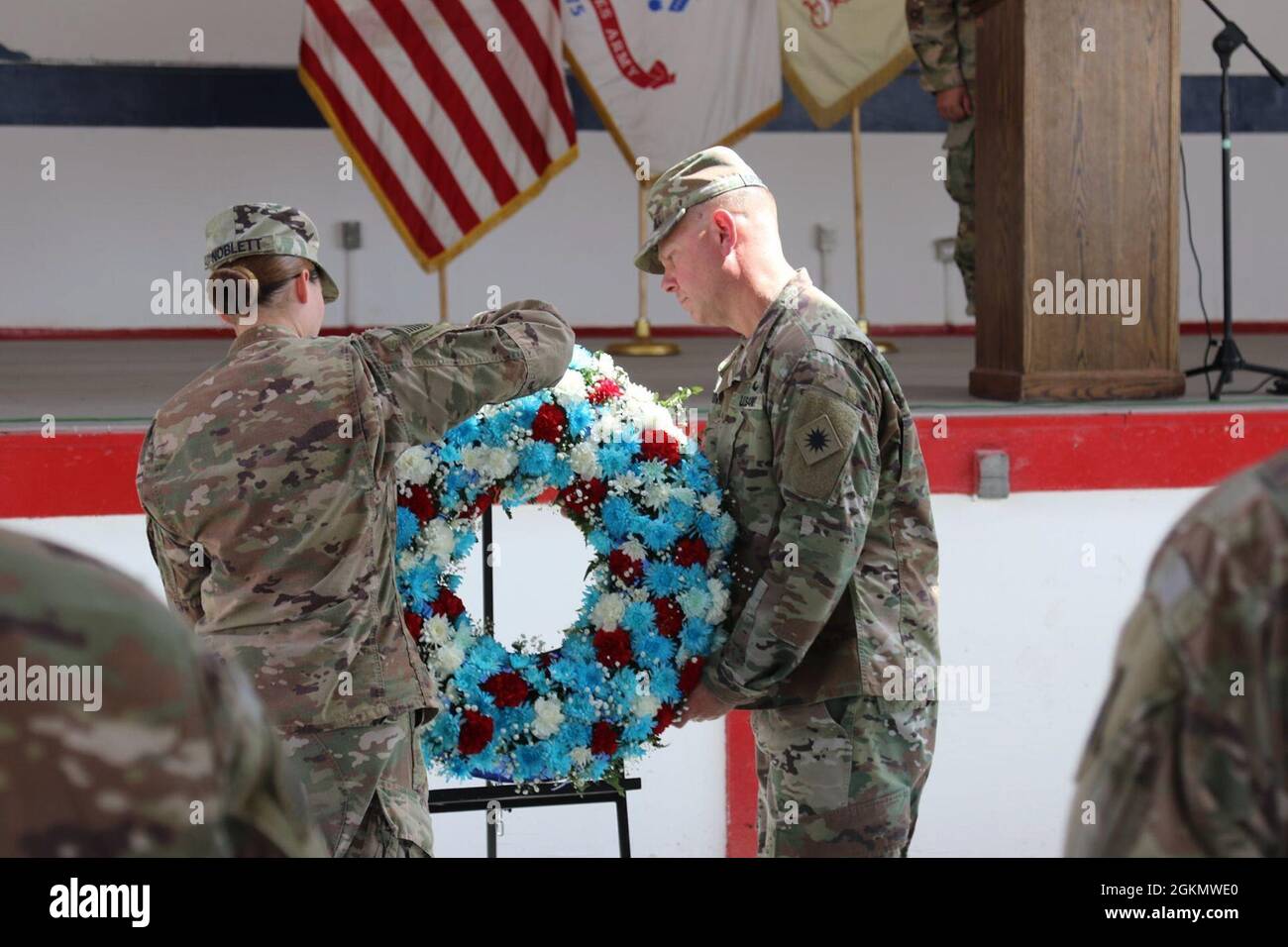 Spc. Abigail Noblett and Col. Alan Gronewold place a wreath during a ...