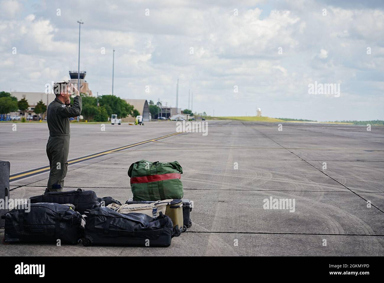 An Airman waves to an incoming aircraft carrying returning deployed ...