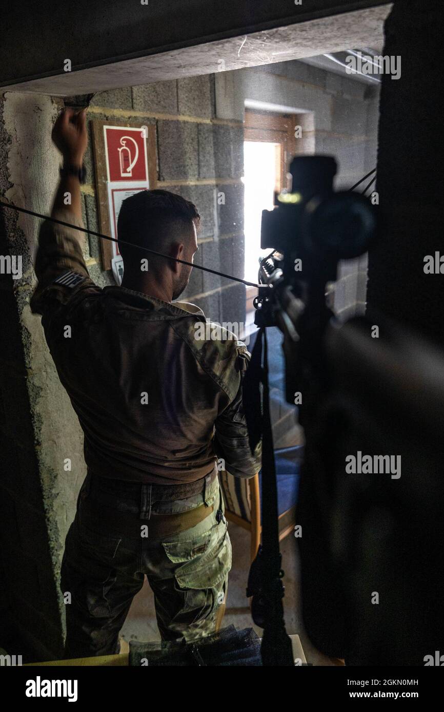 A Greek Special Forces sniper prepares a hide site at the International ...
