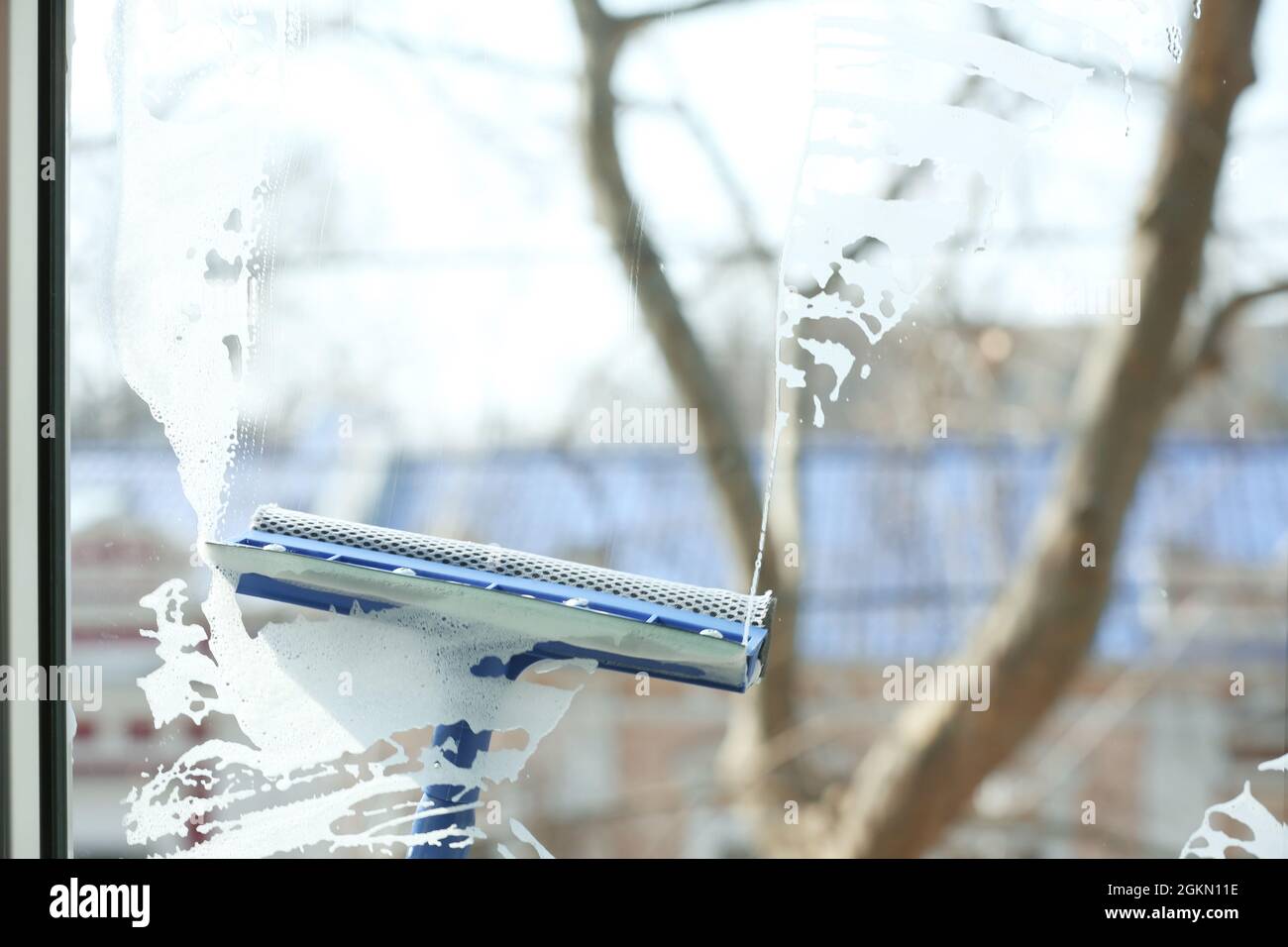 Washing window with special mop, view through glass Stock Photo - Alamy