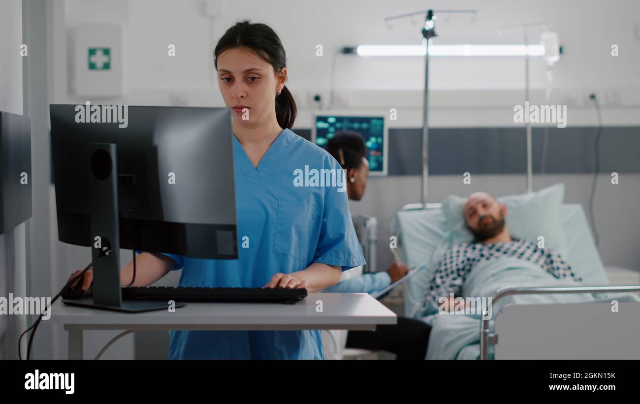Front view of nurse typing medical expertise on computer while in ...