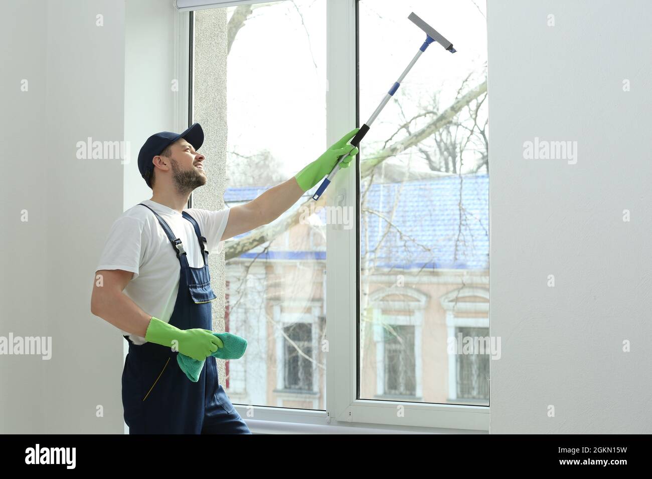 Young man washing window in office Stock Photo - Alamy