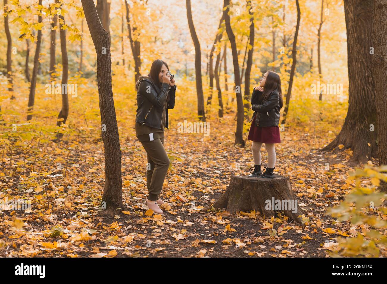 Child girl photographer takes pictures of a mother in the park in ...