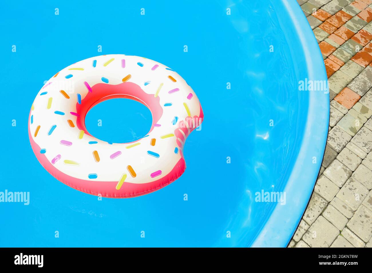 Colorful inflatable donut floating in pool Stock Photo - Alamy