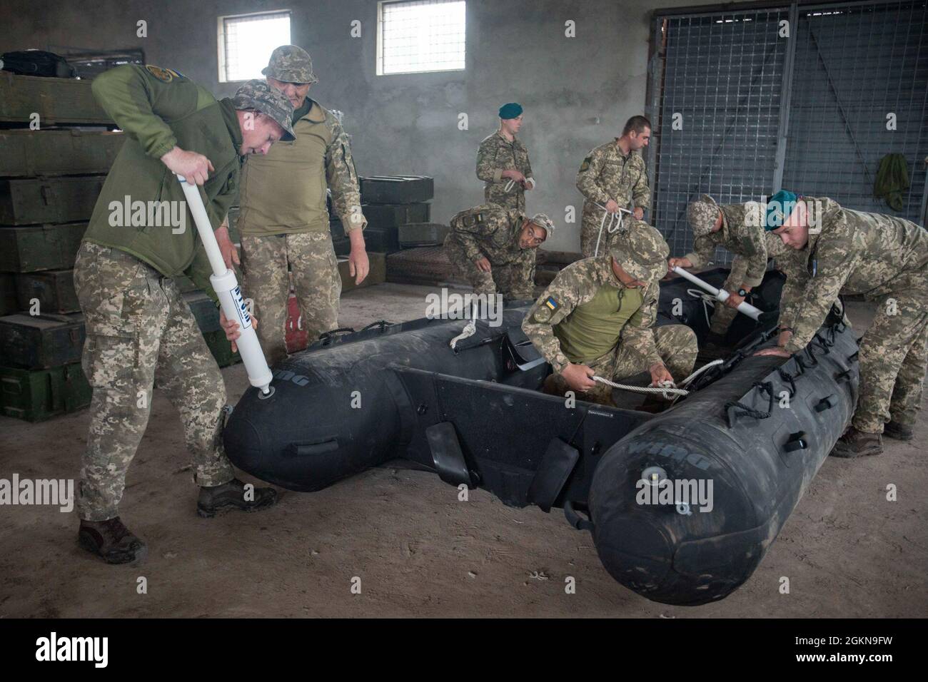 Ukrainian Marines with the 36th Marine Brigade assemble a combat rubber reconnaissance craft ...