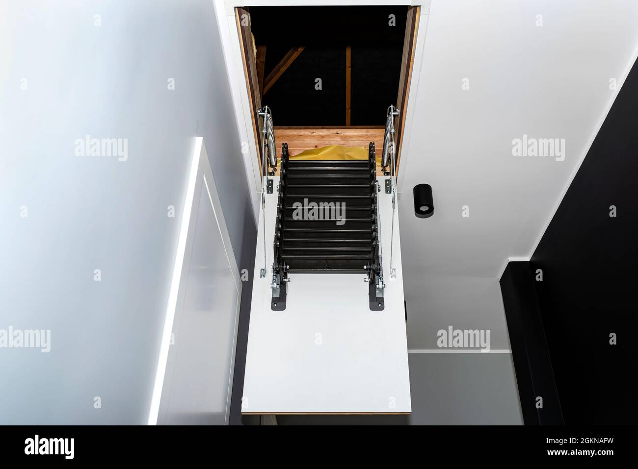 Folding metal stairs to the attic in the ceiling, open hatch and ...