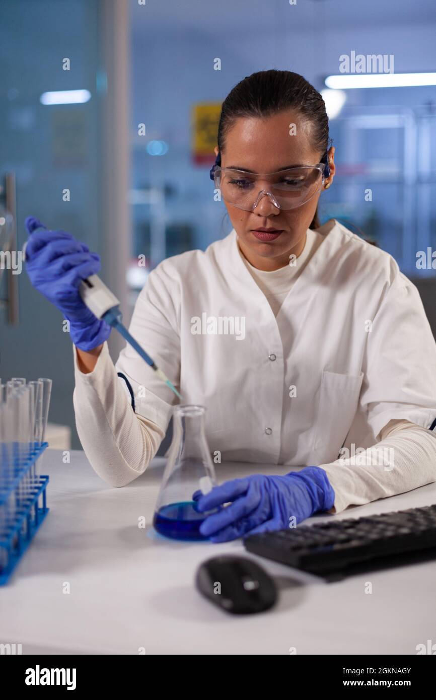 Professional laboratory worker using pipette for jar container in ...
