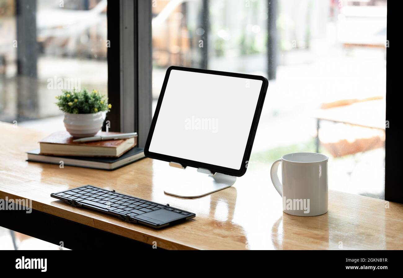Portable workspace with blank screen tablet on wooden desk with copy ...