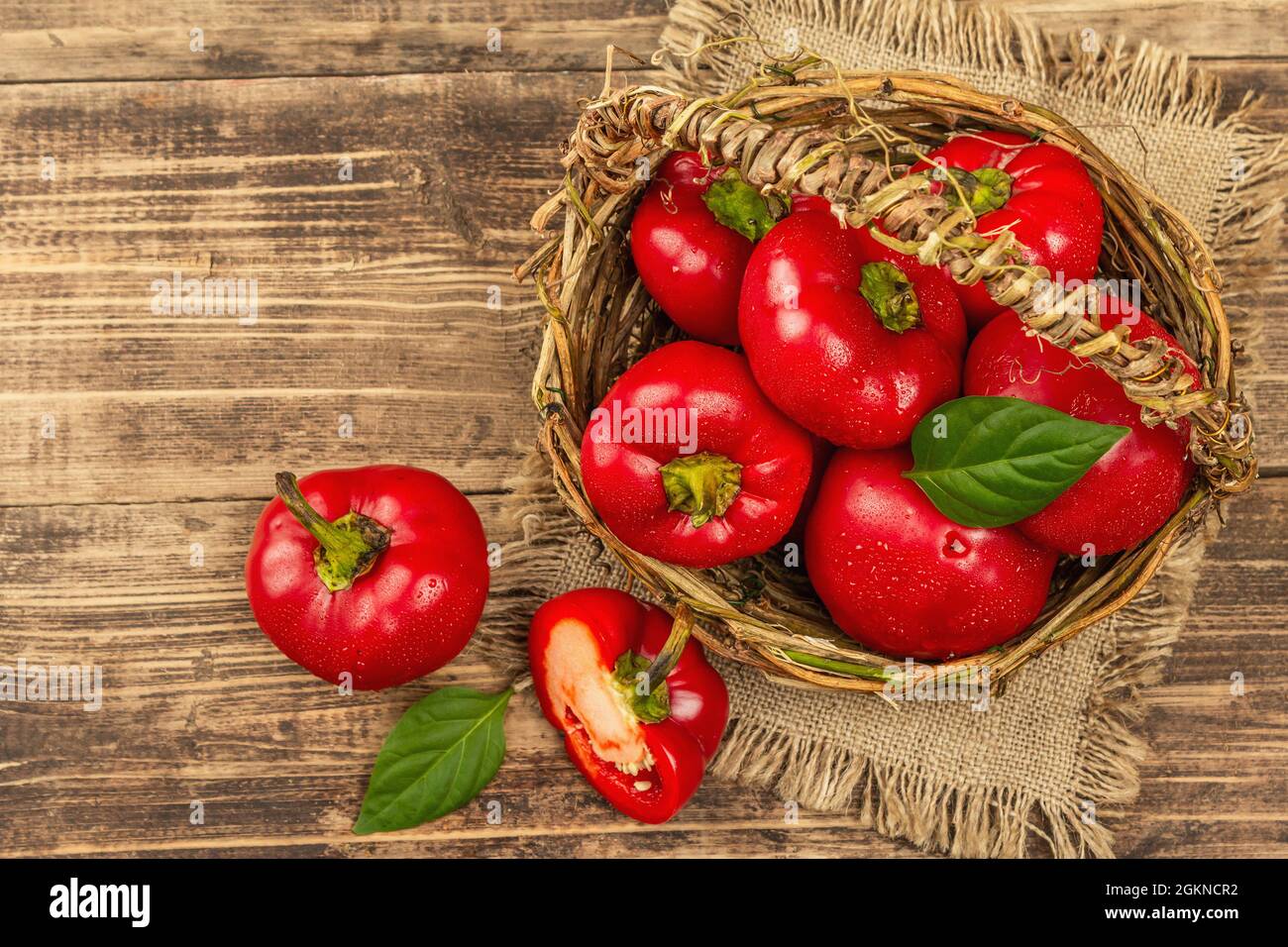 Ripe red round peppers in a handmade wicker basket. Fresh vegetables ...