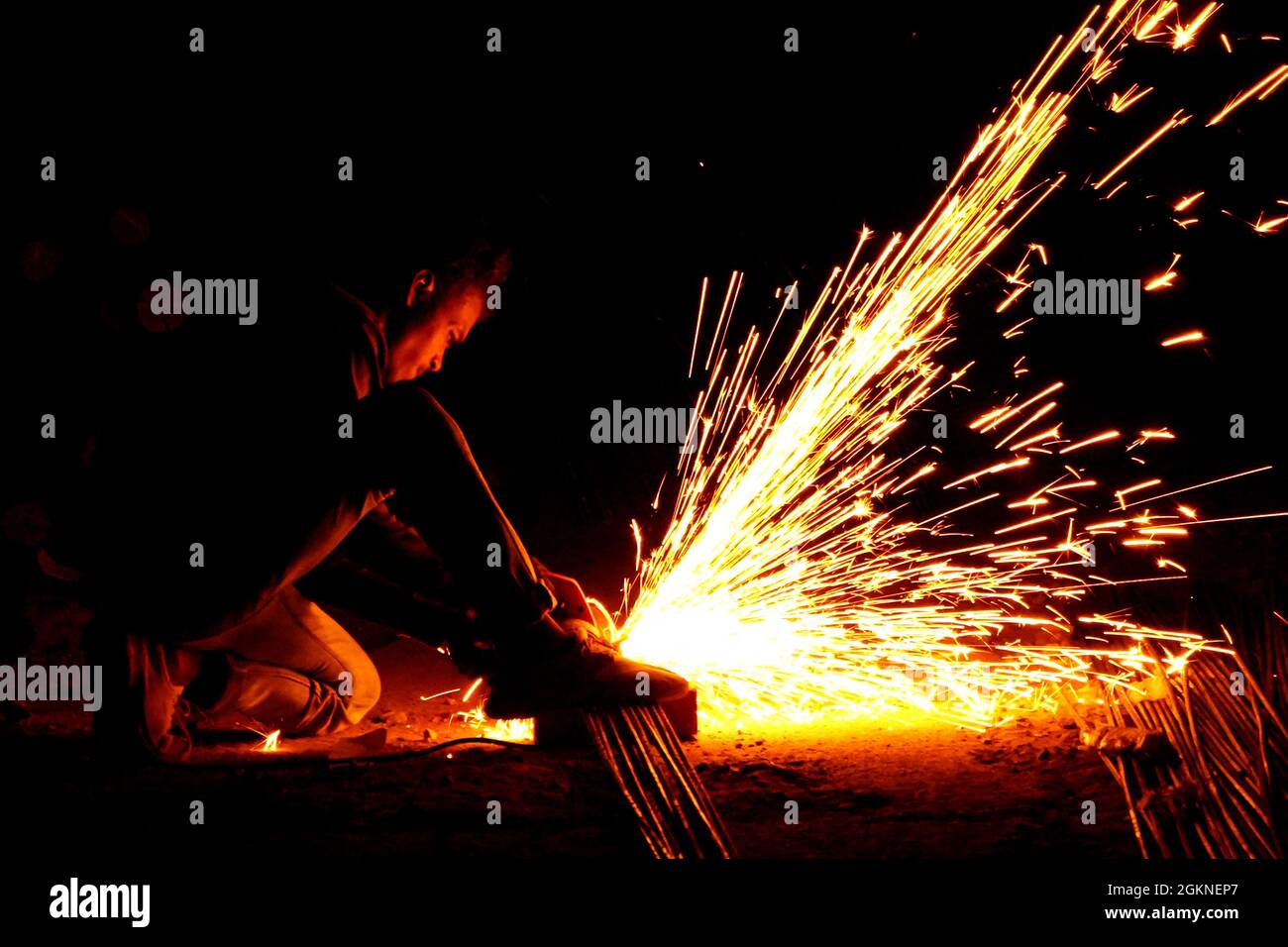 Indian worker cutting iron using grinder on the construction site in ...