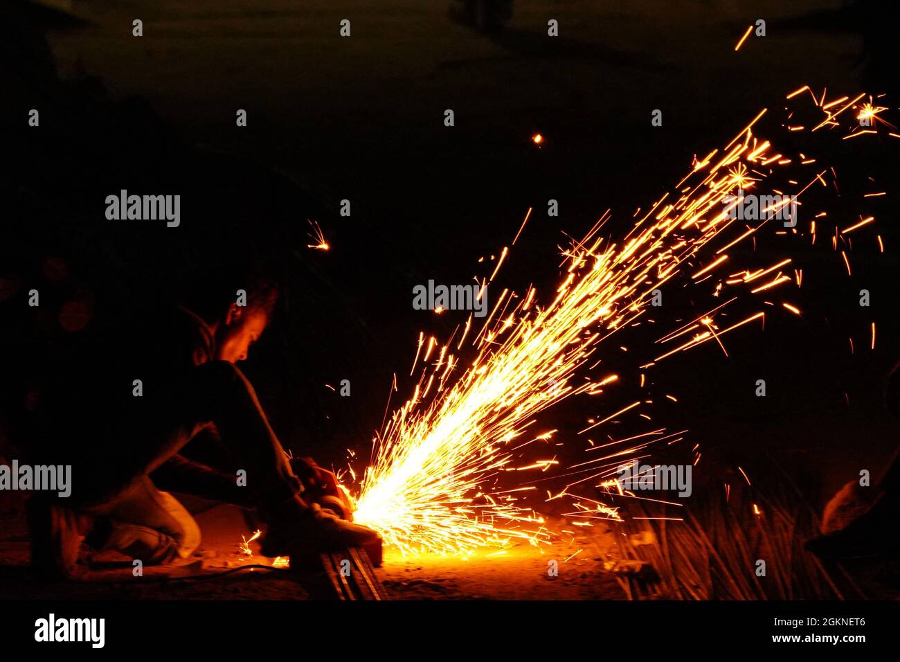 Indian worker cutting iron using grinder on the construction site in ...