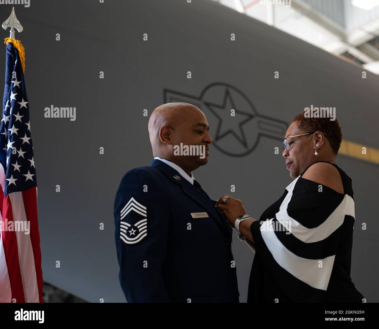Dawn Andrews, places a retirement pin onto the uniform of her husband ...