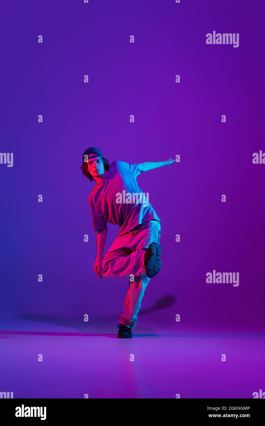 Stylish sportive boy dancing hip-hop in stylish clothes on colorful ...