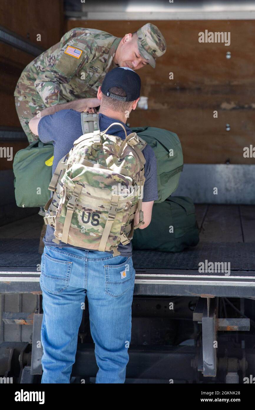 A military intelligence Soldier loads his gear into a truck mobilizing ...