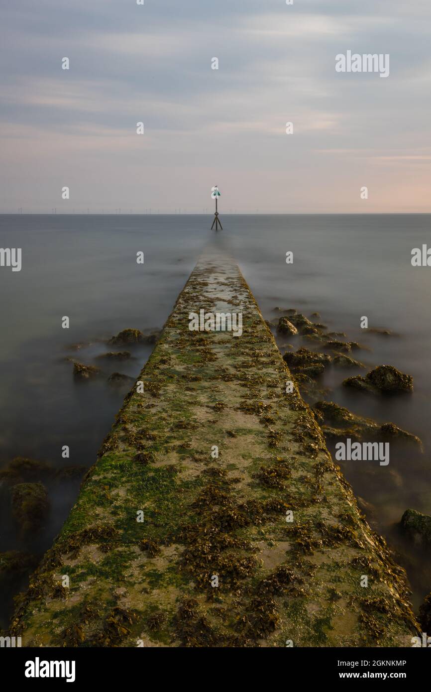 Stone groyne at sunrise on the North Wales coast. Rocks and seaweed ...