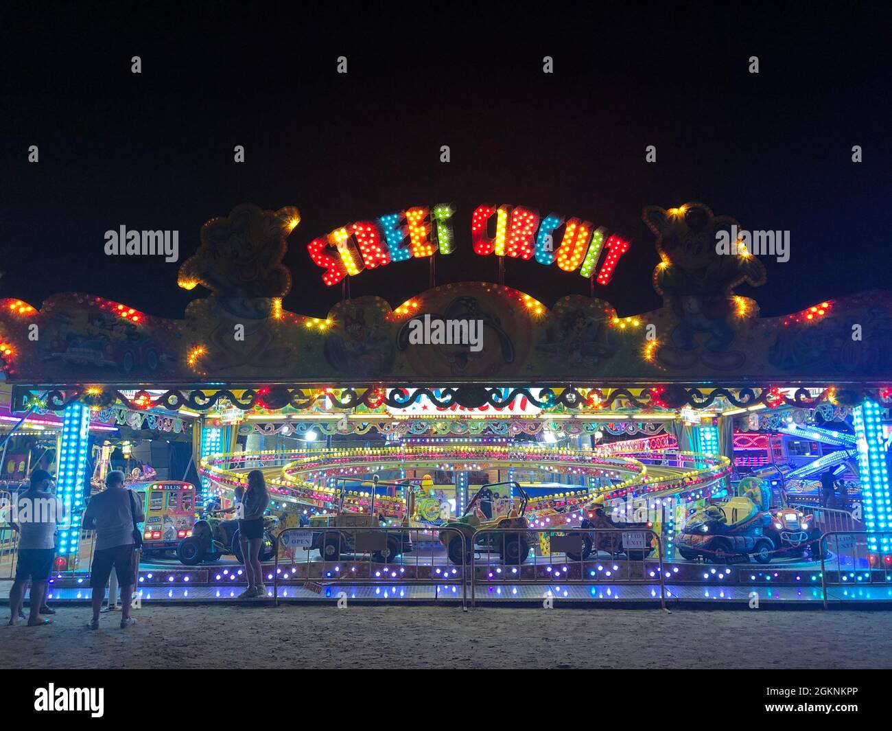 Amusement park inside the exhibition. People have fun at night. Low ...