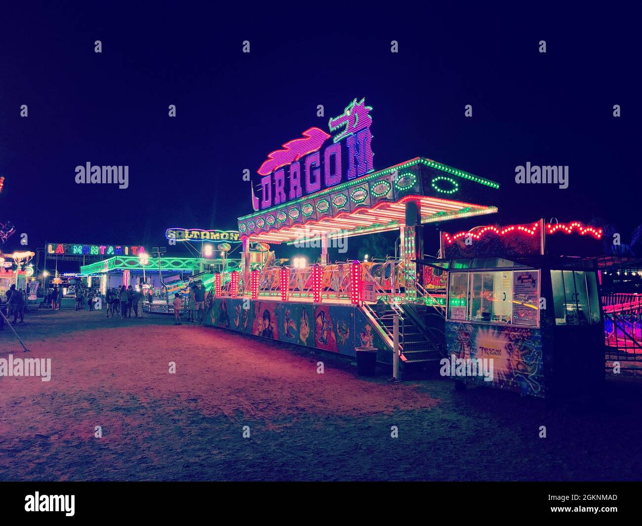 Amusement park inside the exhibition. People have fun at night. Low ...
