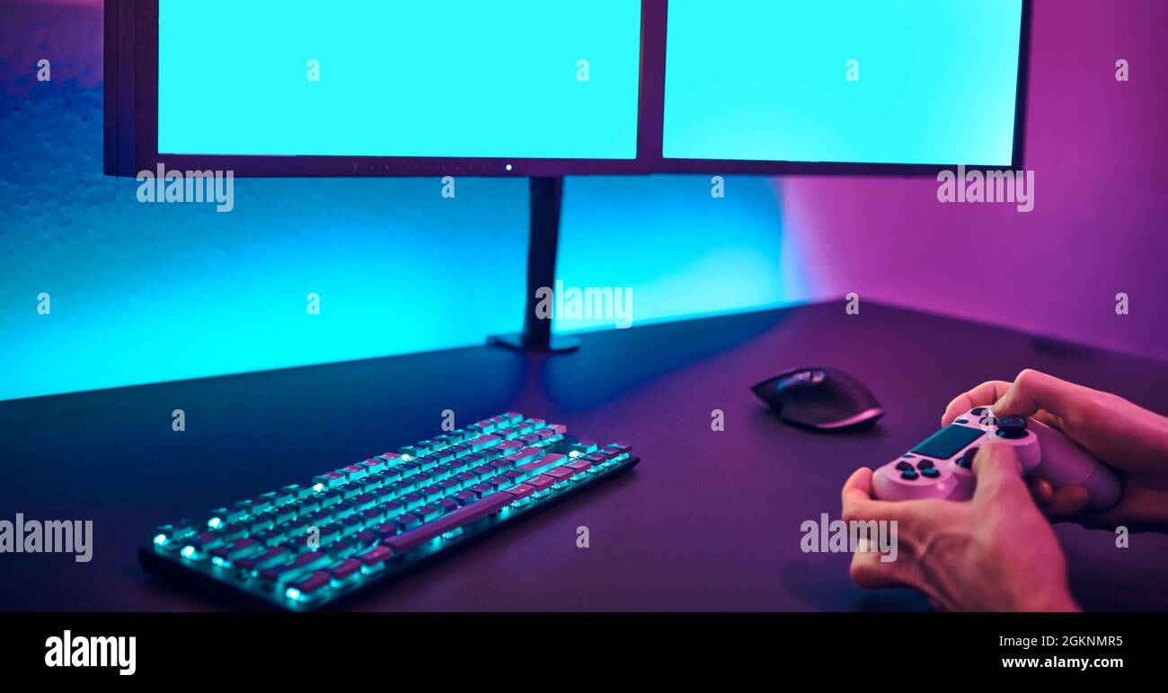 Hands holding game controller. Dual display and cyan / purple ...