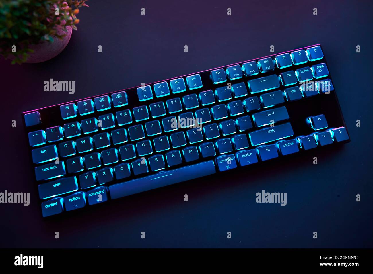 High angle view of cyan backlighted gaming computer keyboard laying on ...