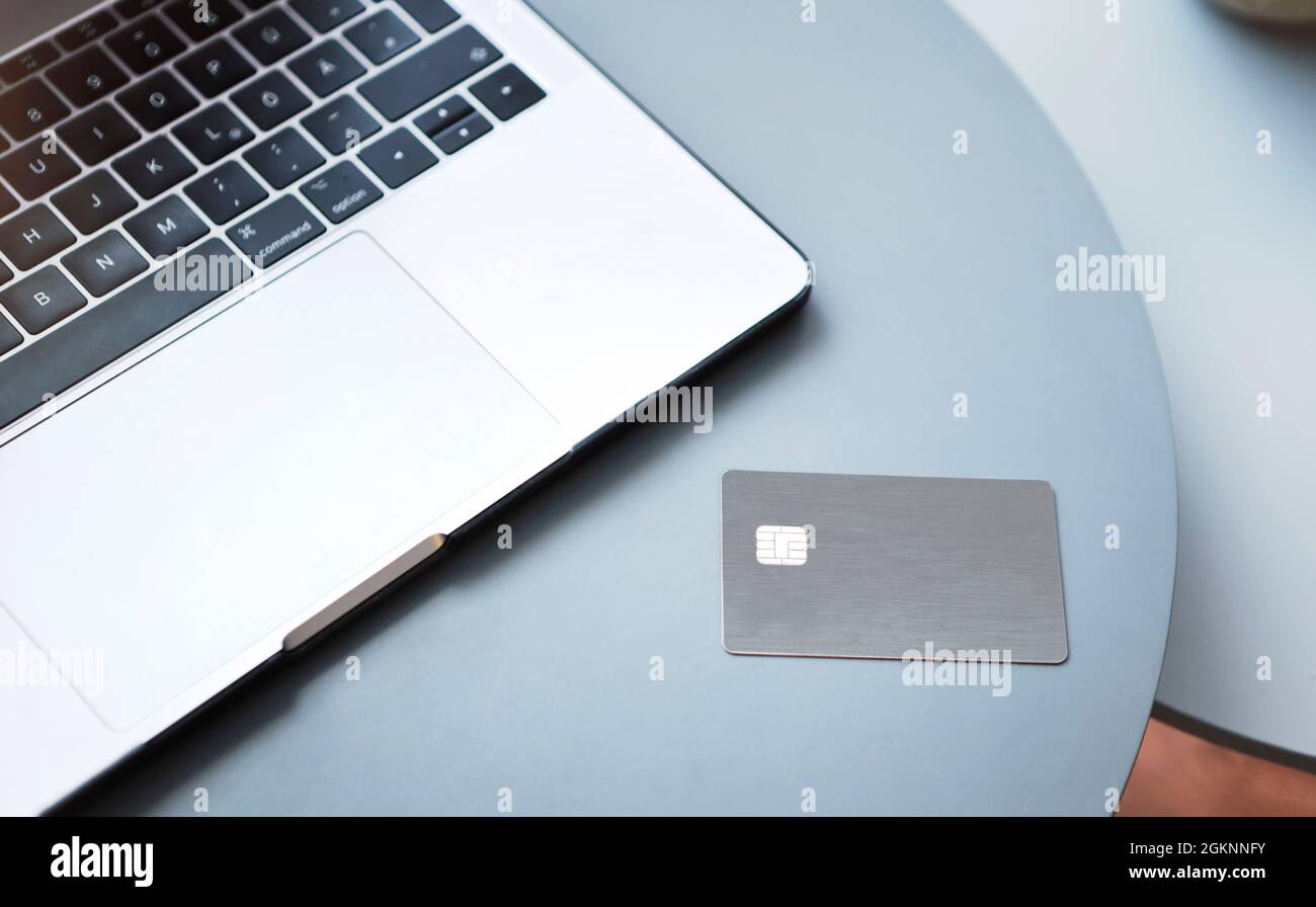 Laptop, electronic chip card and smartphone on blue round table. Paying ...
