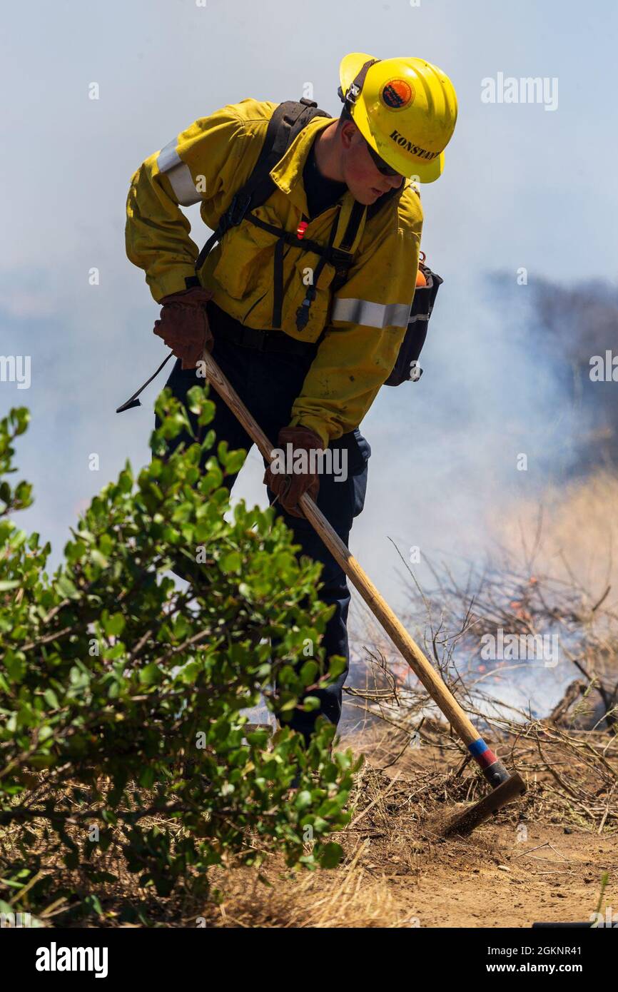 A firefighter with Los Angeles County Fire Department clears brush ...