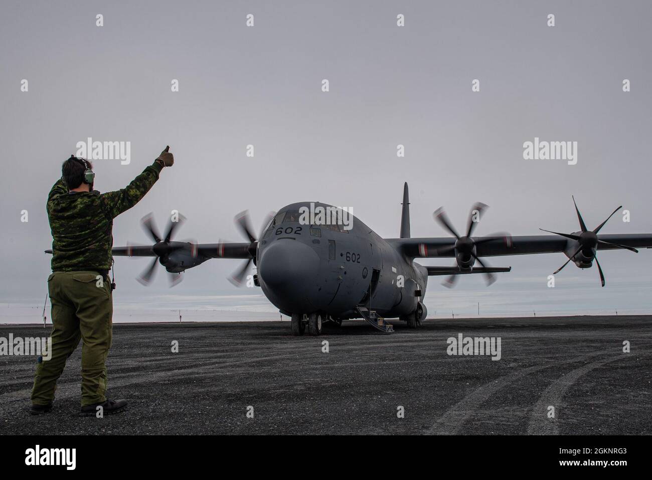 A member from 436 Squadron provides ground signals to a Royal Canadian ...
