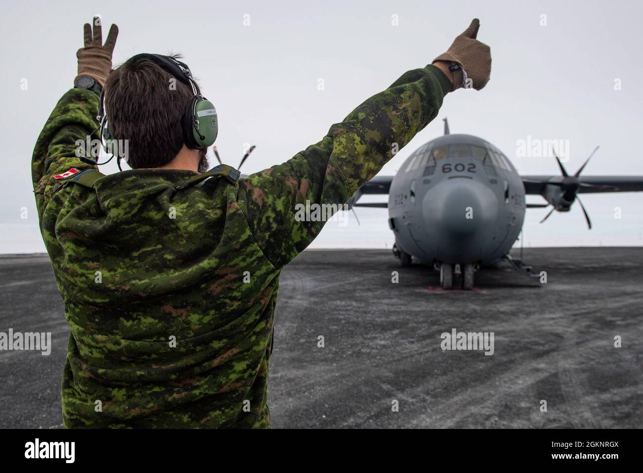 A member from 436 Squadron provides ground signals to a Royal Canadian ...