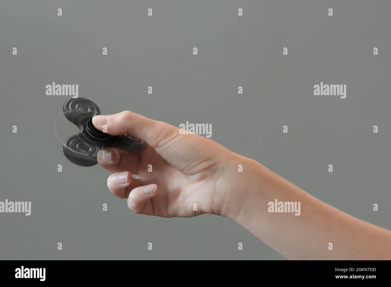 Woman rolling modern spinner on grey background Stock Photo - Alamy