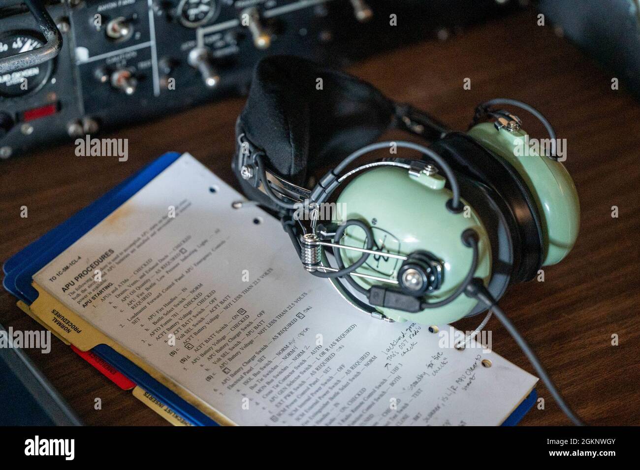 An auxiliary power unit checklist and an aviation headset rest on the ...