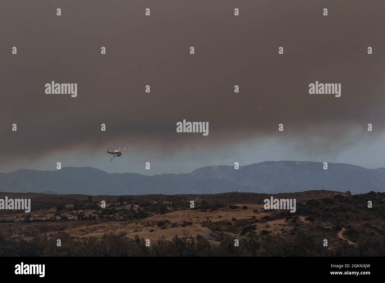 A Bell 412EP twin-engine helicopter carries water in an effort to ...