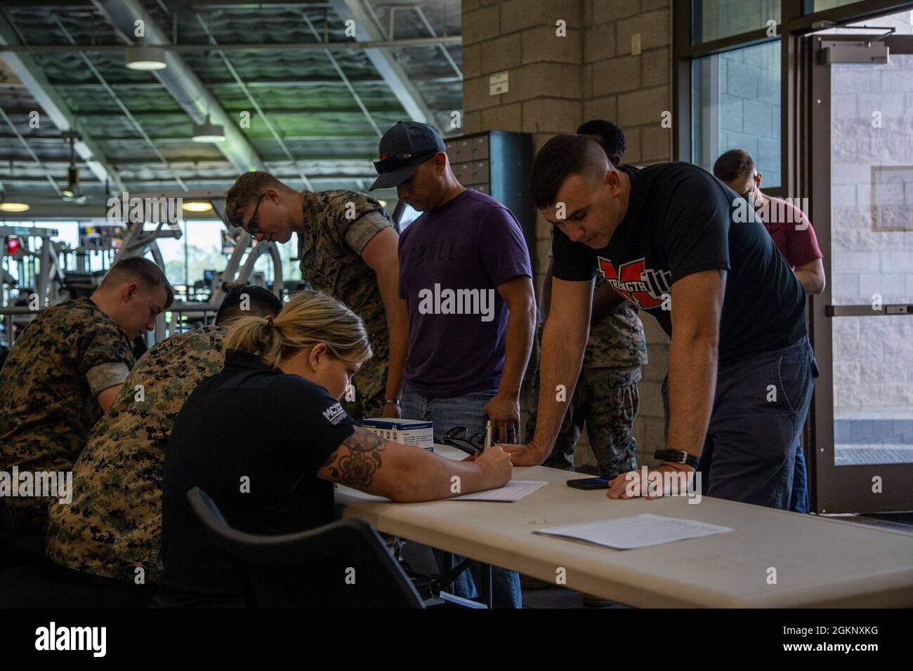 U.S. Marines sign into a log book at Paige Fieldhouse in the 11 Area of ...