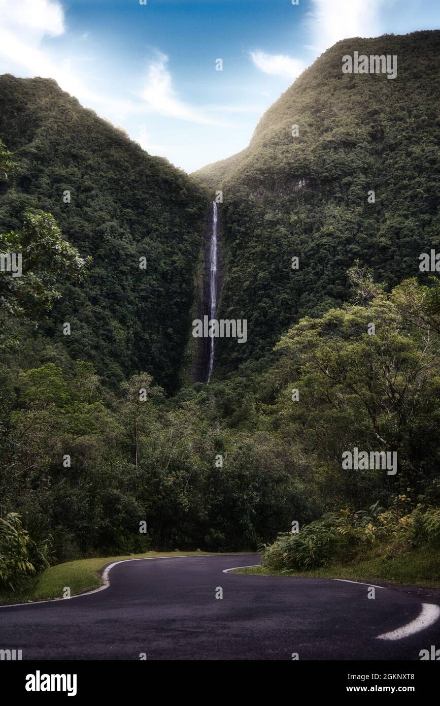 A high waterfall in the middle tropical mountains from a road at ...