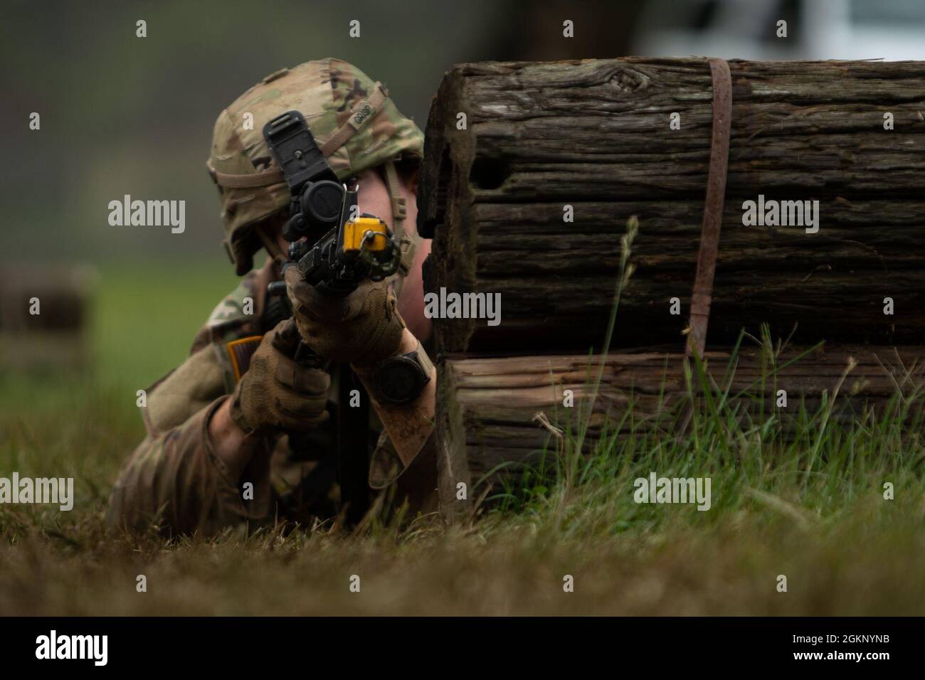 A Cadet takes aim from behind cover during a Fire and Maneuver exercise ...