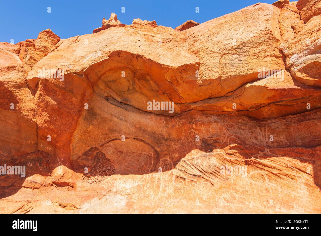 Striking view of Aboriginal rock art or petroglyphs in red sandstone ...