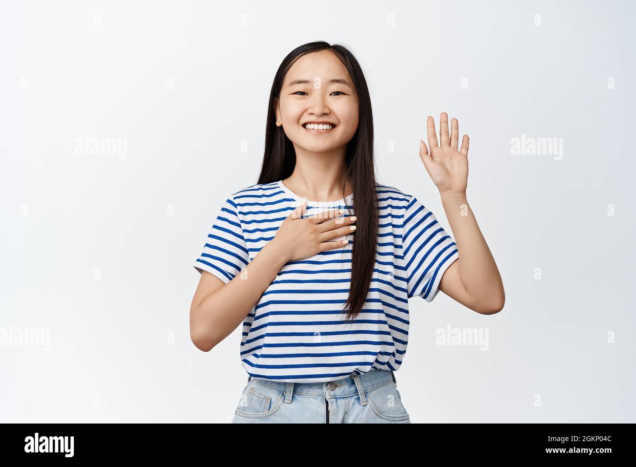 Happy Smiling Asian Girl Raising One Hand Put Palm On Heart Swearing