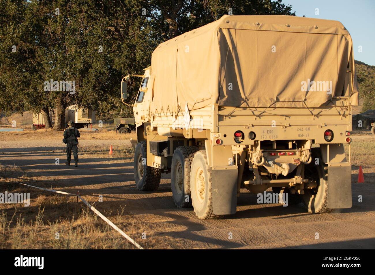 A Solider ground guide another fellow soldier driving a light medium ...