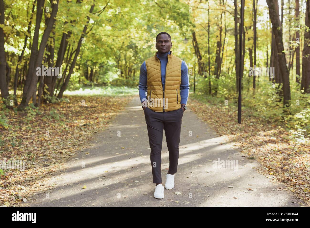 African american student walking in the park in autumn season Stock ...