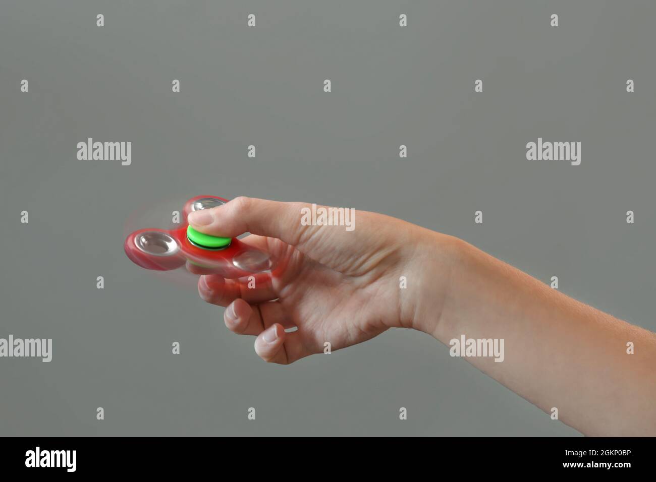 Woman rolling modern spinner on grey background Stock Photo - Alamy