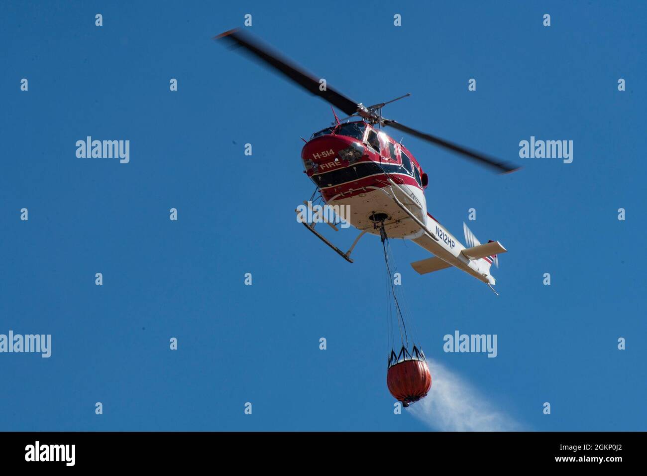 A helicopter carries water to assist responders on the ground of the ...