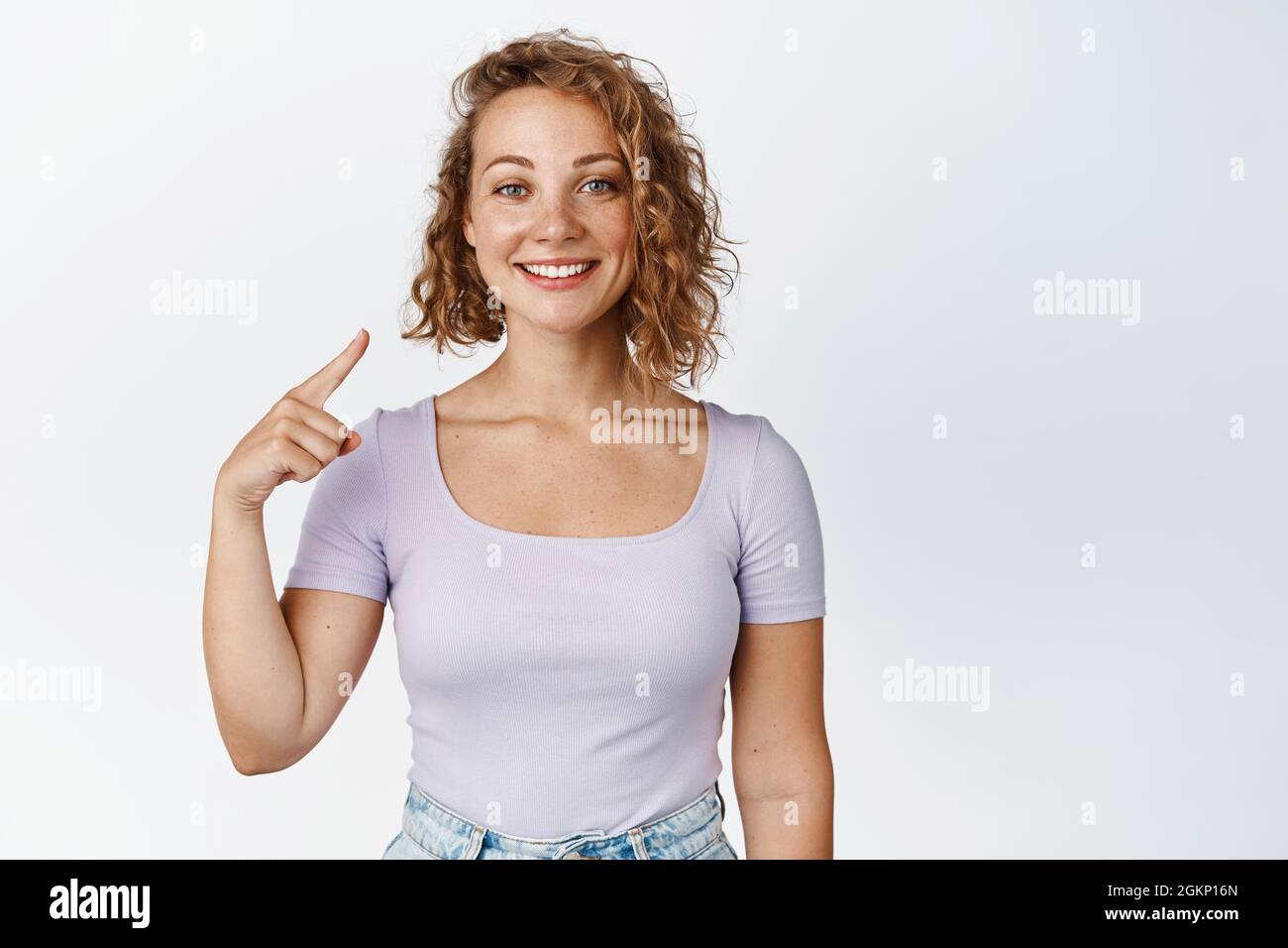 Happy smiling girl with blond short hair, pointing finger at herself ...