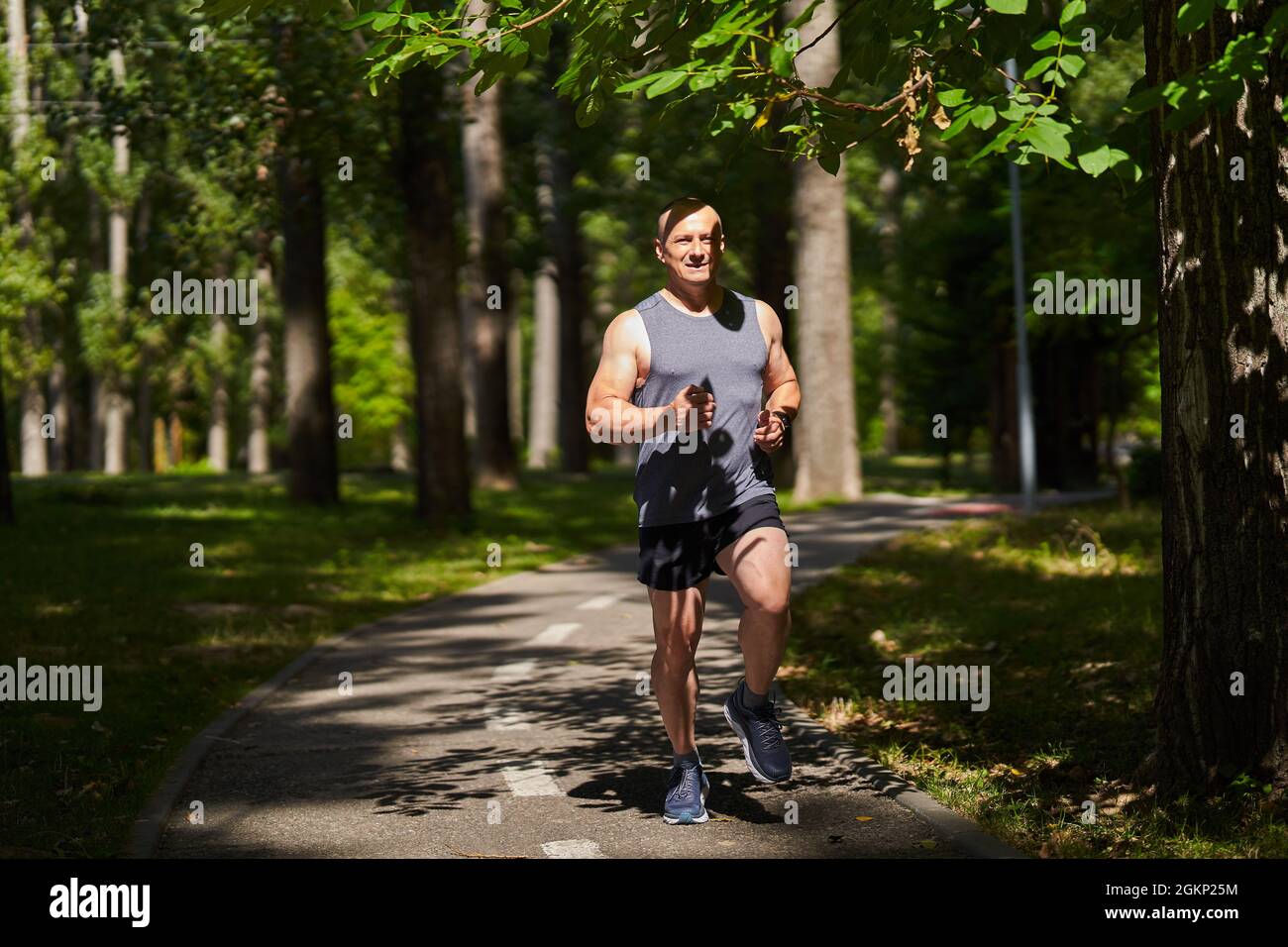 Athletic man marathon runner training in the park alleys Stock Photo ...