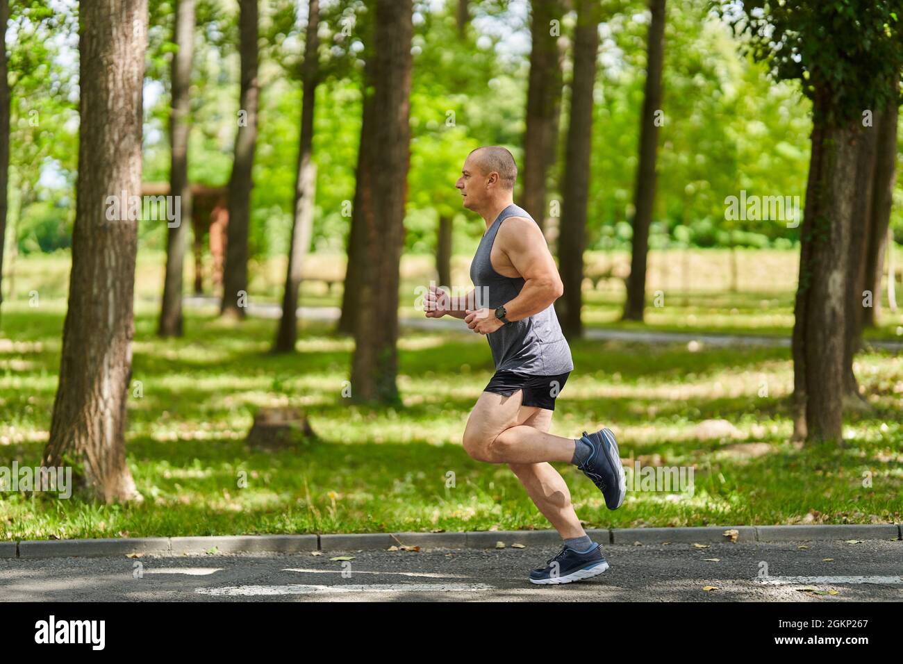 Athletic man marathon runner training in the park alleys Stock Photo ...