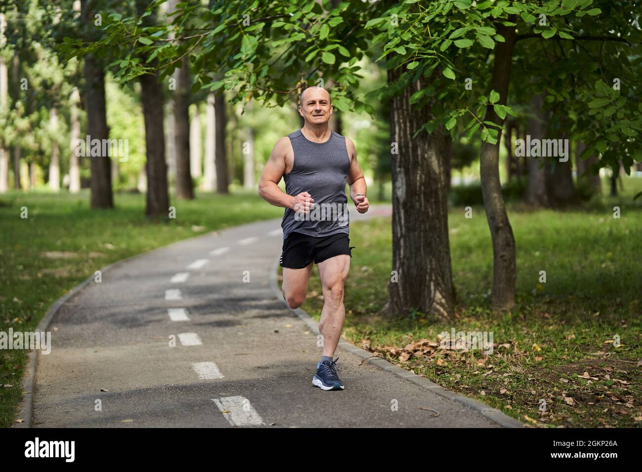 Athletic man marathon runner training in the park alleys Stock Photo ...