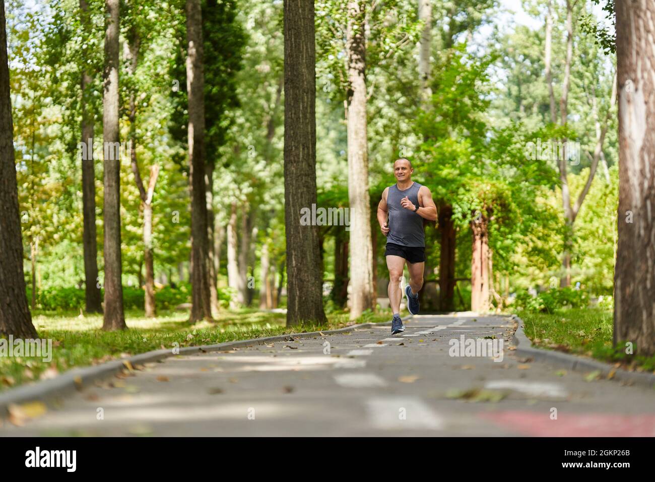 Athletic man marathon runner training in the park alleys Stock Photo ...